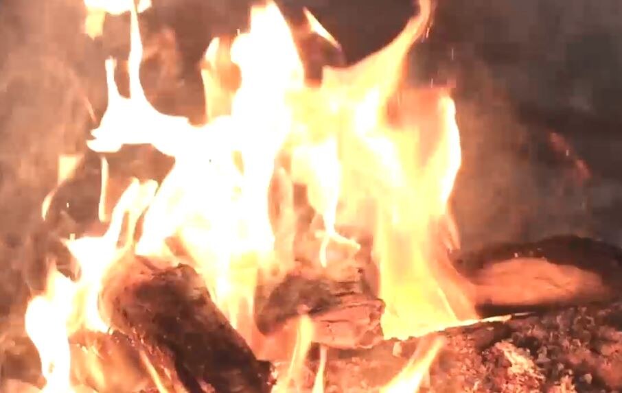 The fire crackles at the riverside cookup. - ABC News