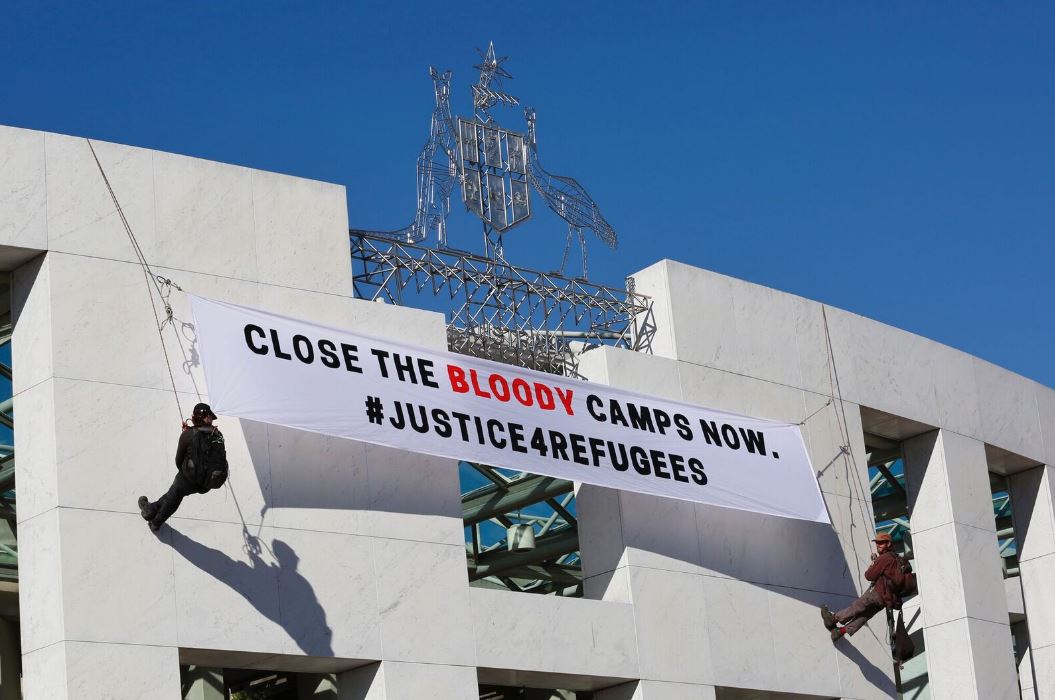Parliament House protesters abseil down building, dye fountain red ...