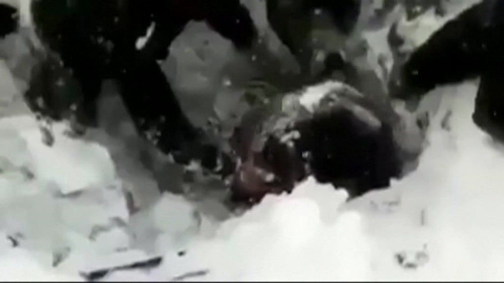 People rescuing a man buried by snow after heavy snowfall triggered ...