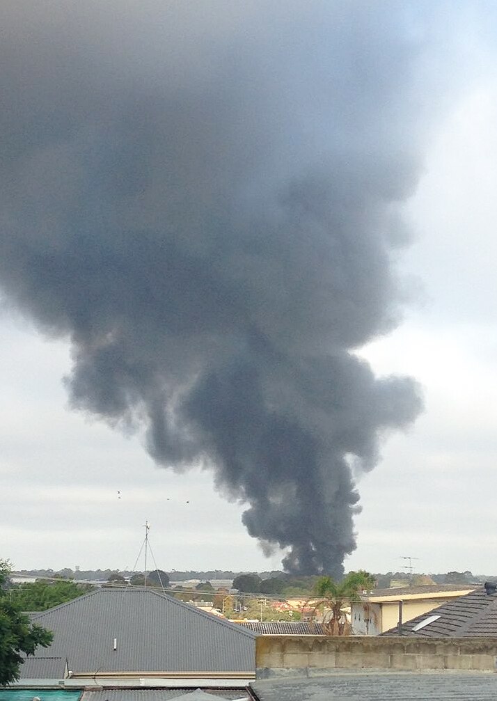 Fire crews contain a burning factory that sent black smoke into sky ...