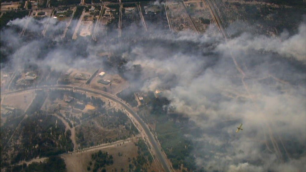 Firefighter injured by falling tree branch in bushfire burning near ...