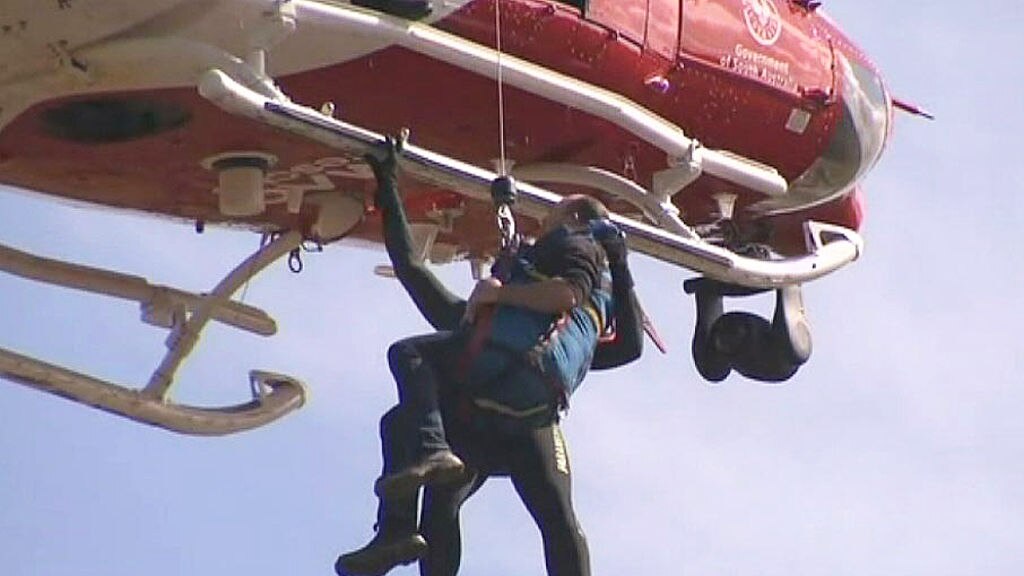 A family is winched to safety after being caught on rocks at Mannum ...