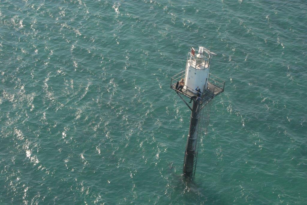 Fishermen climb channel marker after boat overturns in rough seas off ...