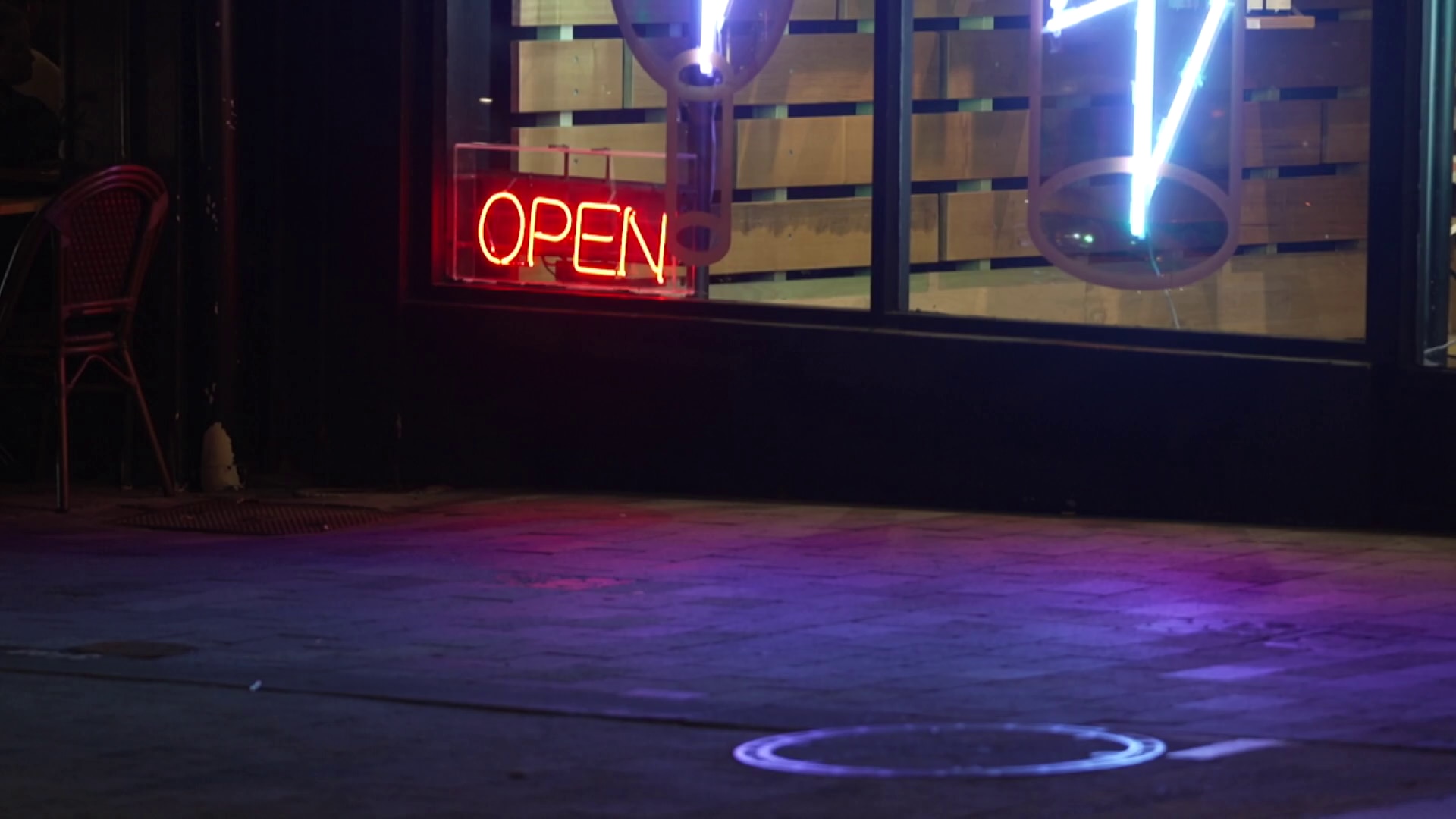 An 'open' sign on a dark city street. - ABC News
