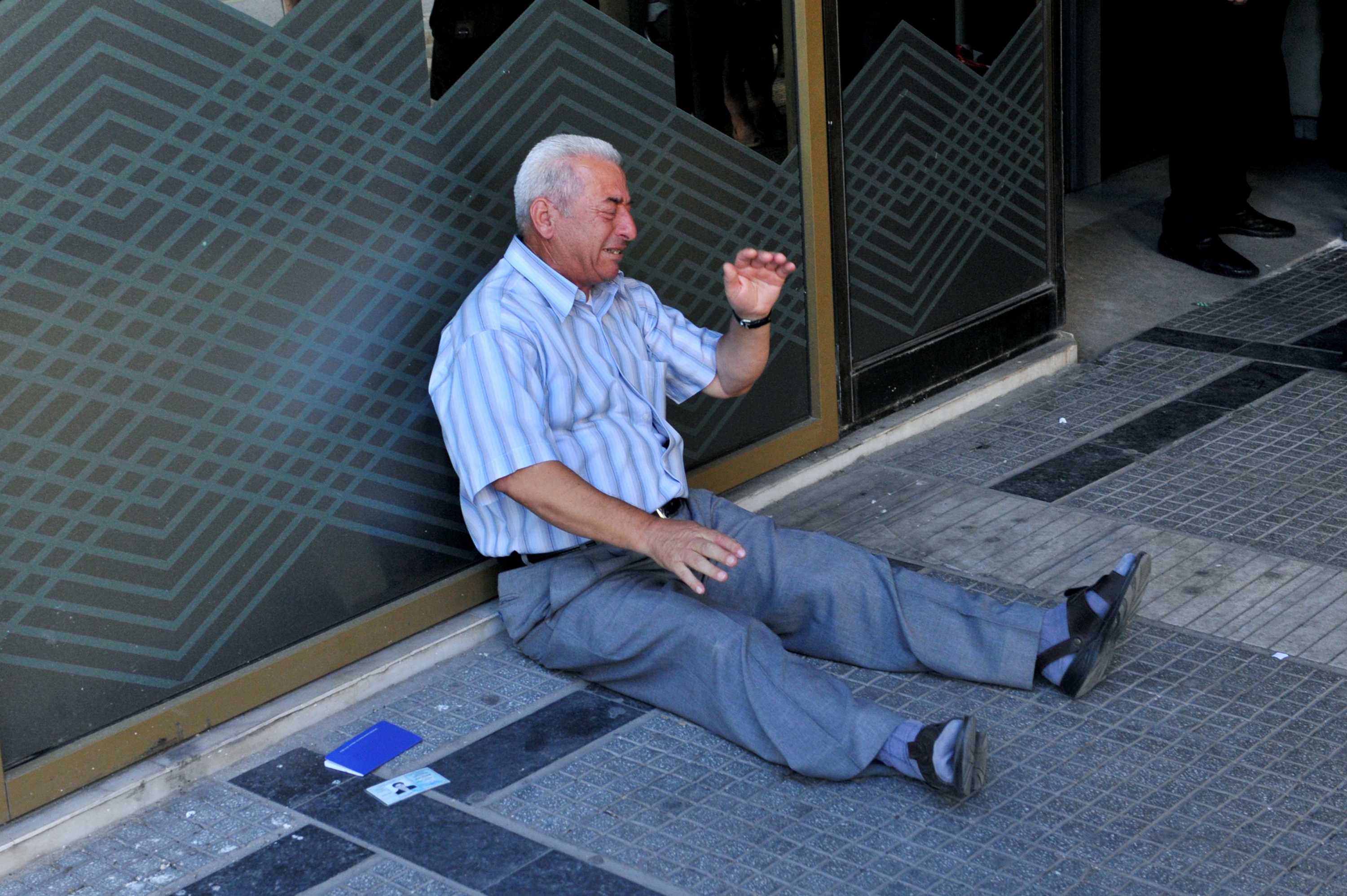 Greek debt crisis: Photograph of elderly man collapsed outside bank ...