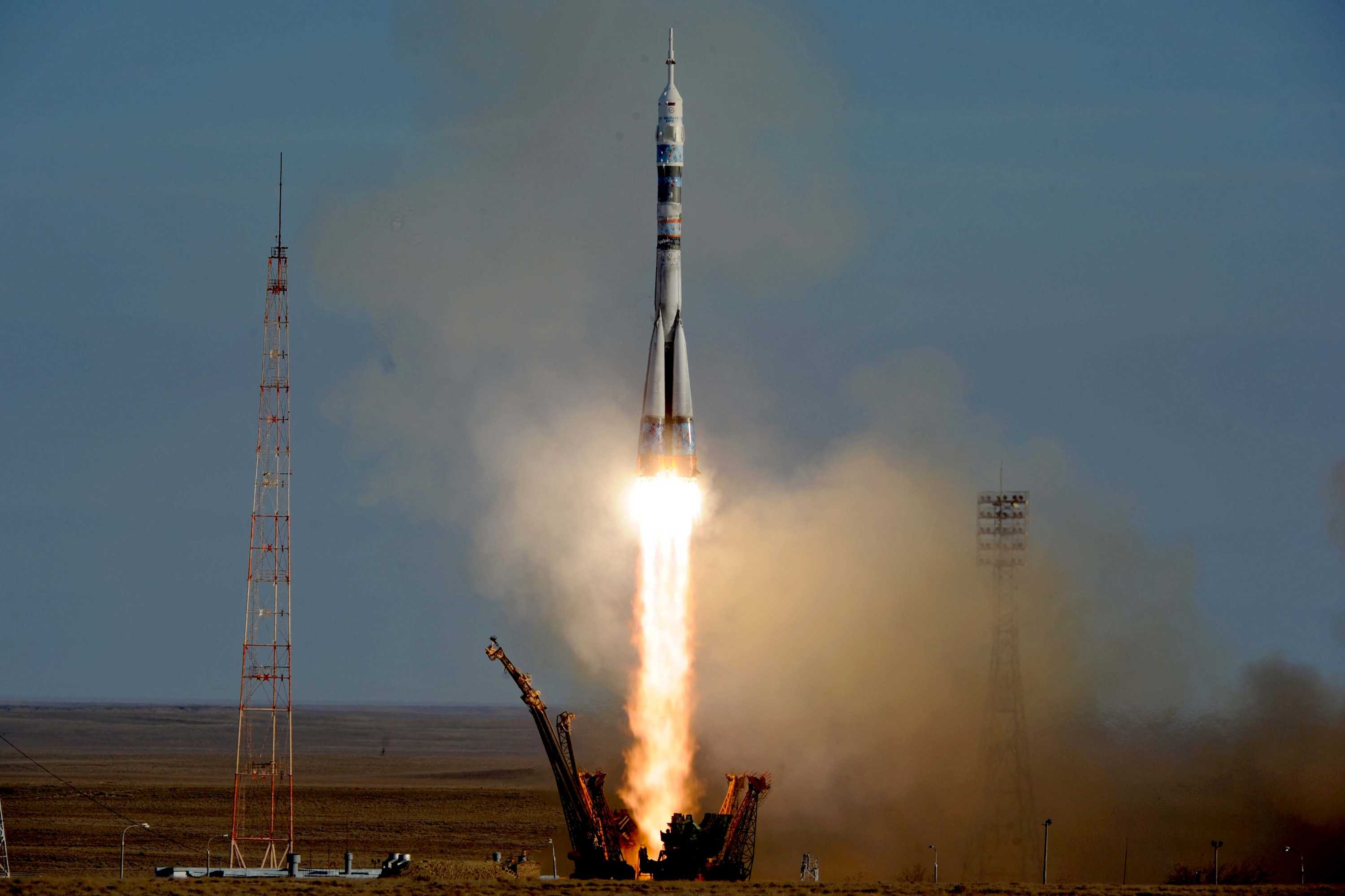 Russian rocket takes three astronauts and Sochi Olympic torch to space ...