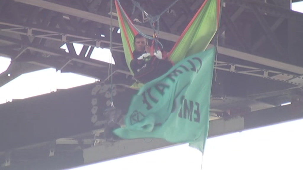 Climate protester hangs off Brisbane's Story Bridge - ABC News