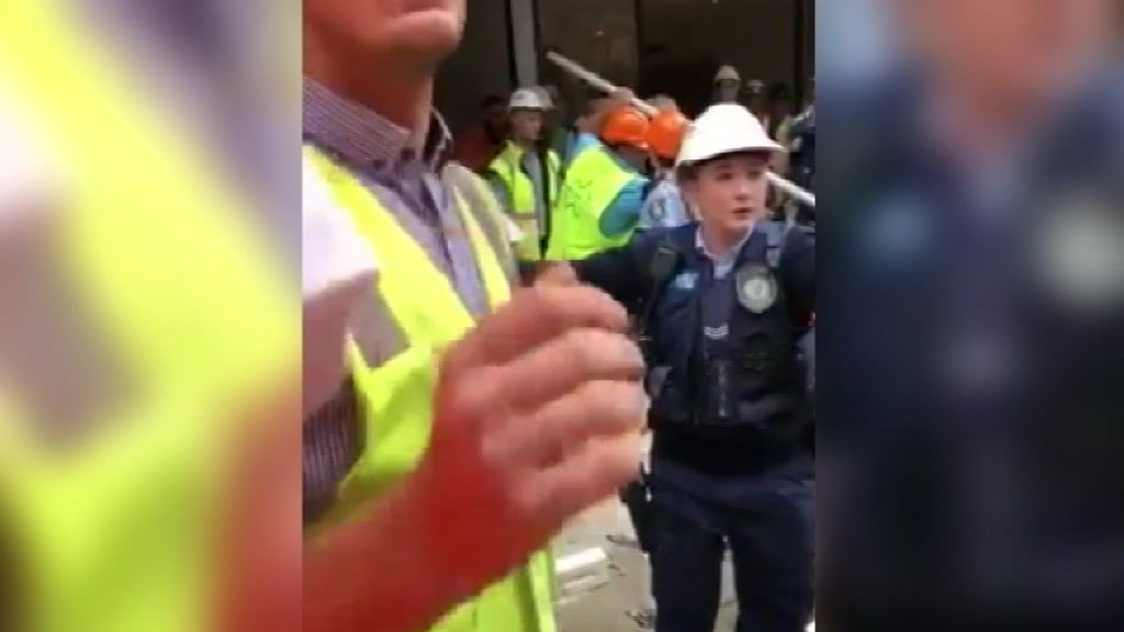Workers fight with police to save their trapped colleagues. - ABC News