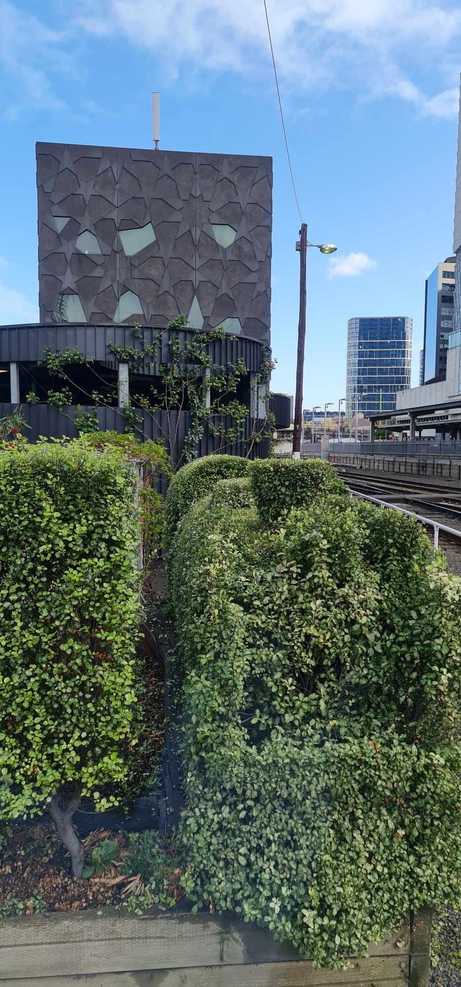 V-Line train driver behind locomotive-shaped hedges at Melbourne's ...