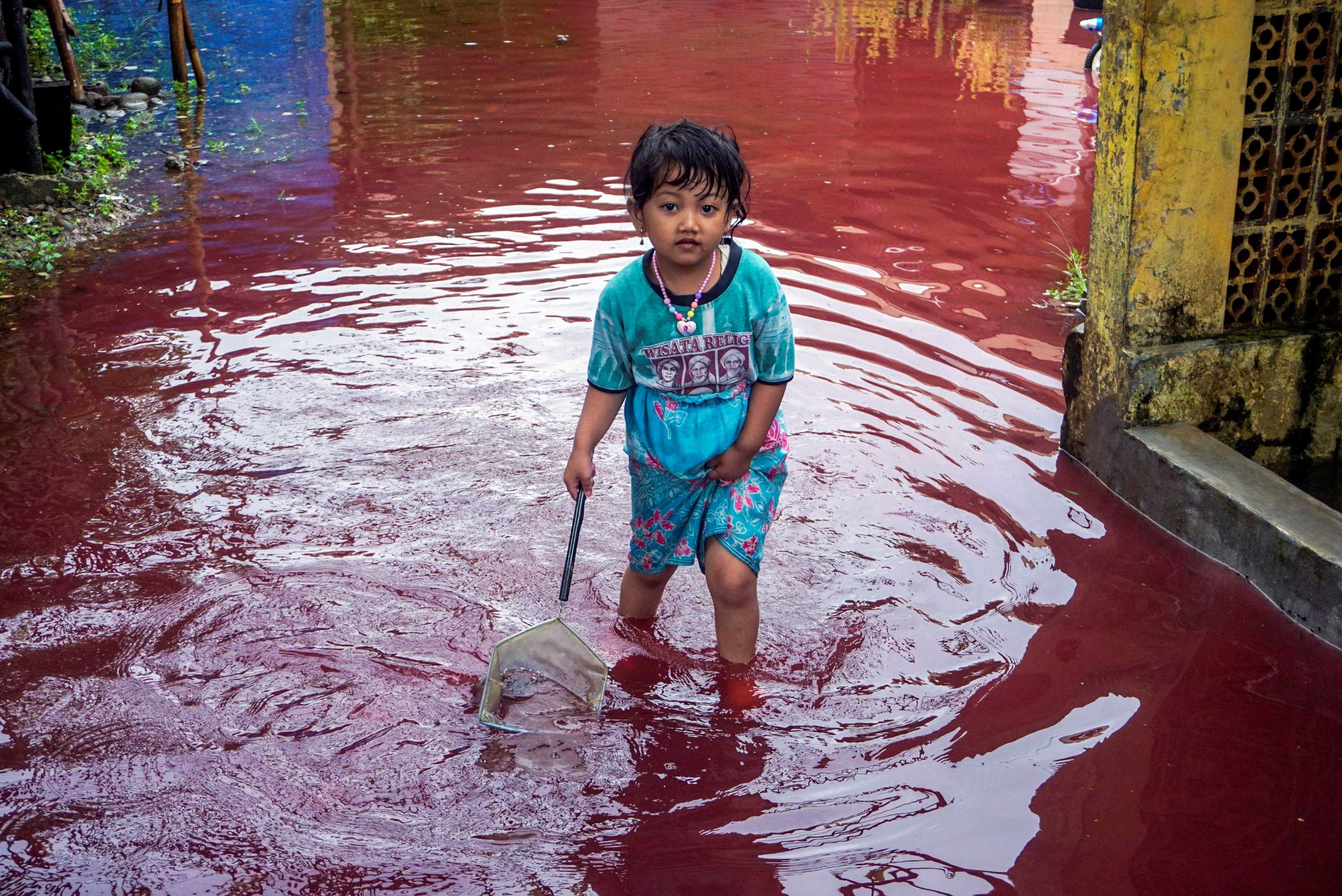 Indonesian town turns blood red after flood hits batik textiles factory ...