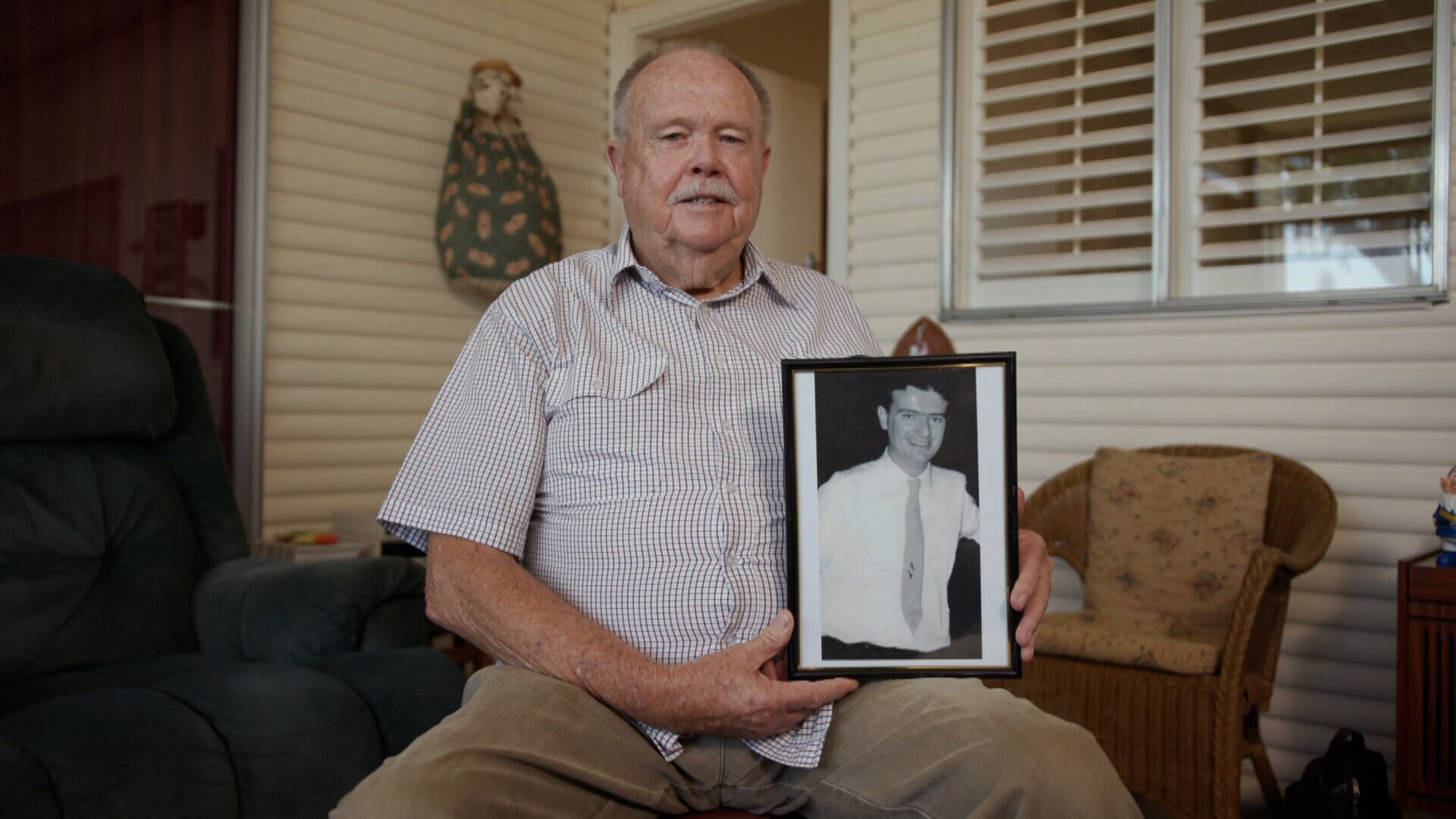 John Rowan holds a photo of his brother Louis - ABC News