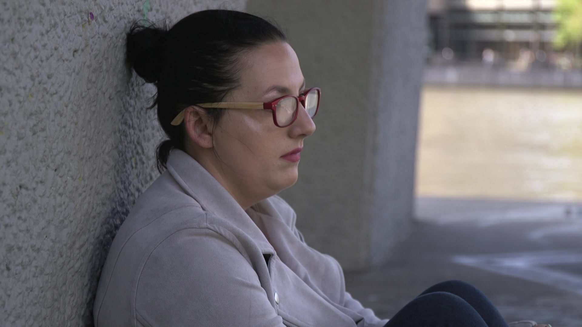 Ash Potter sits by the Yarra River - ABC News