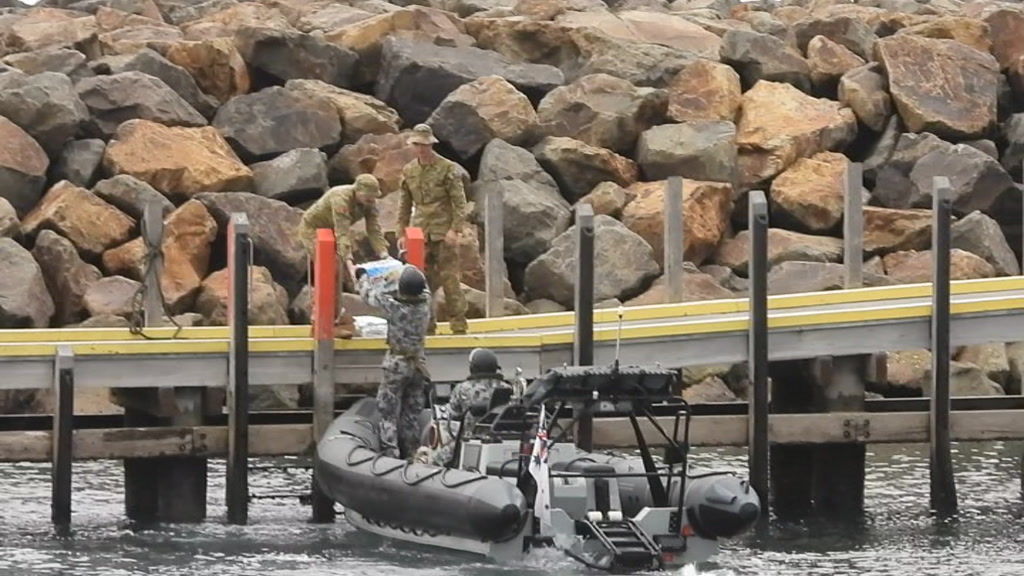 Troops from HMAS Choules and MV Sycamore bringing in water and supplies ...