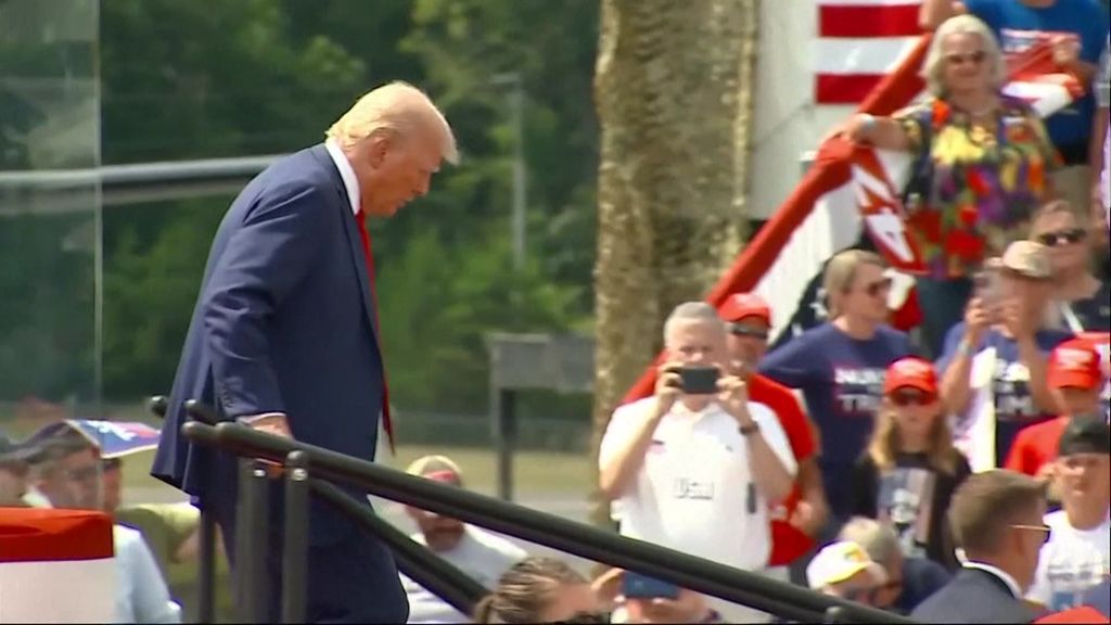 Donald Trump walks off bulletproof glass-protected stage to hug woman ...