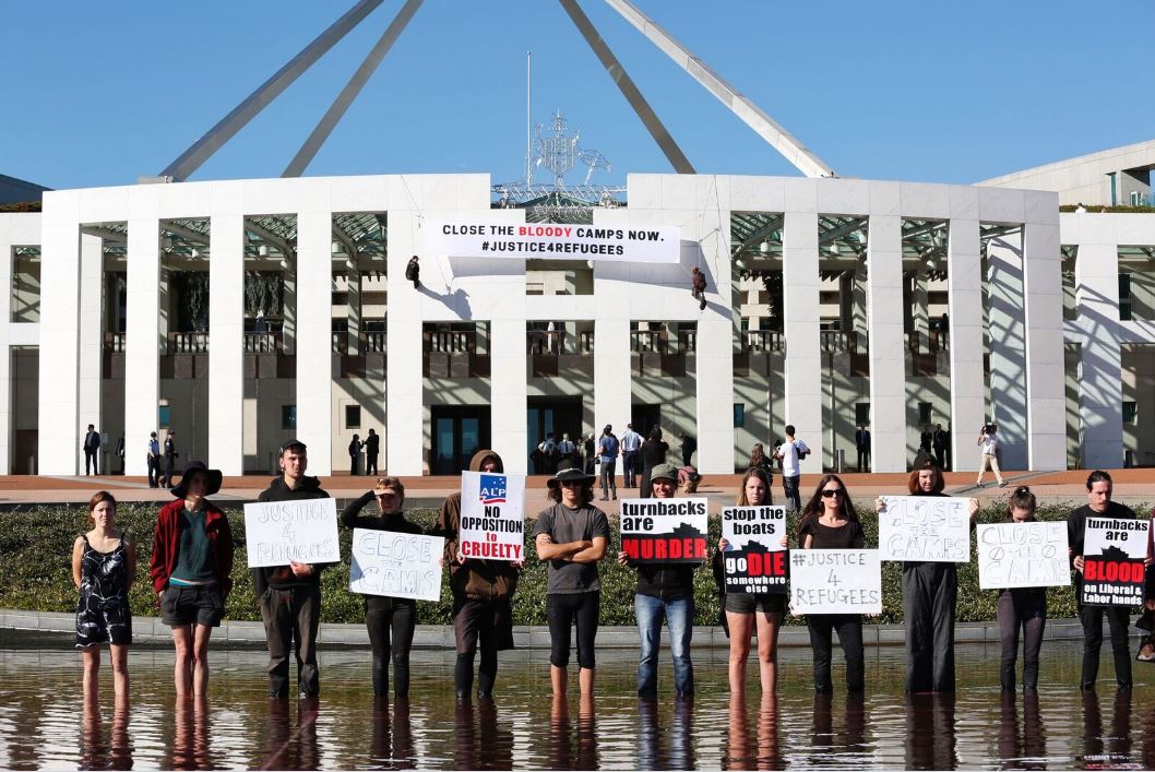 Parliament House protesters abseil down building, dye fountain red ...