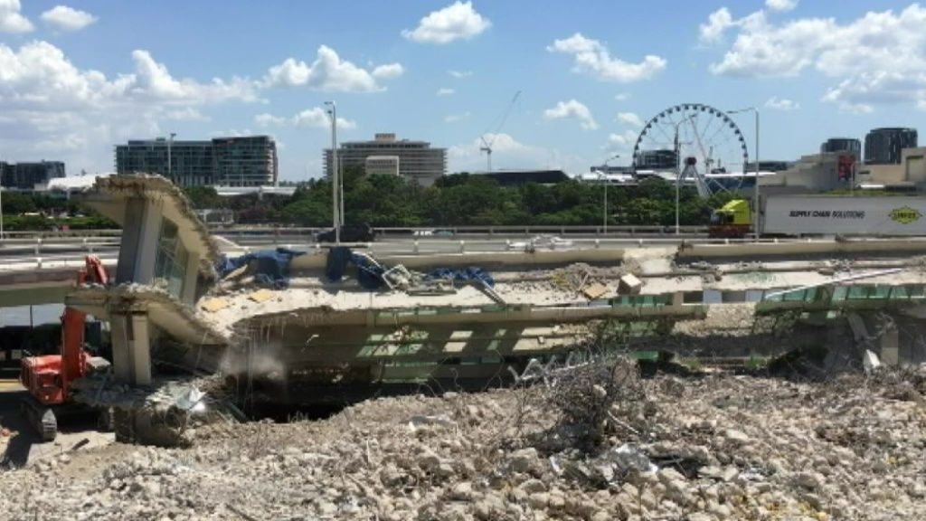 The last section of the Neville Bonner building wall coming down - ABC News