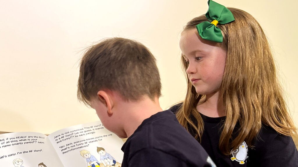 Archie's sisters Audrey and Isla read him a book about his genetic ...