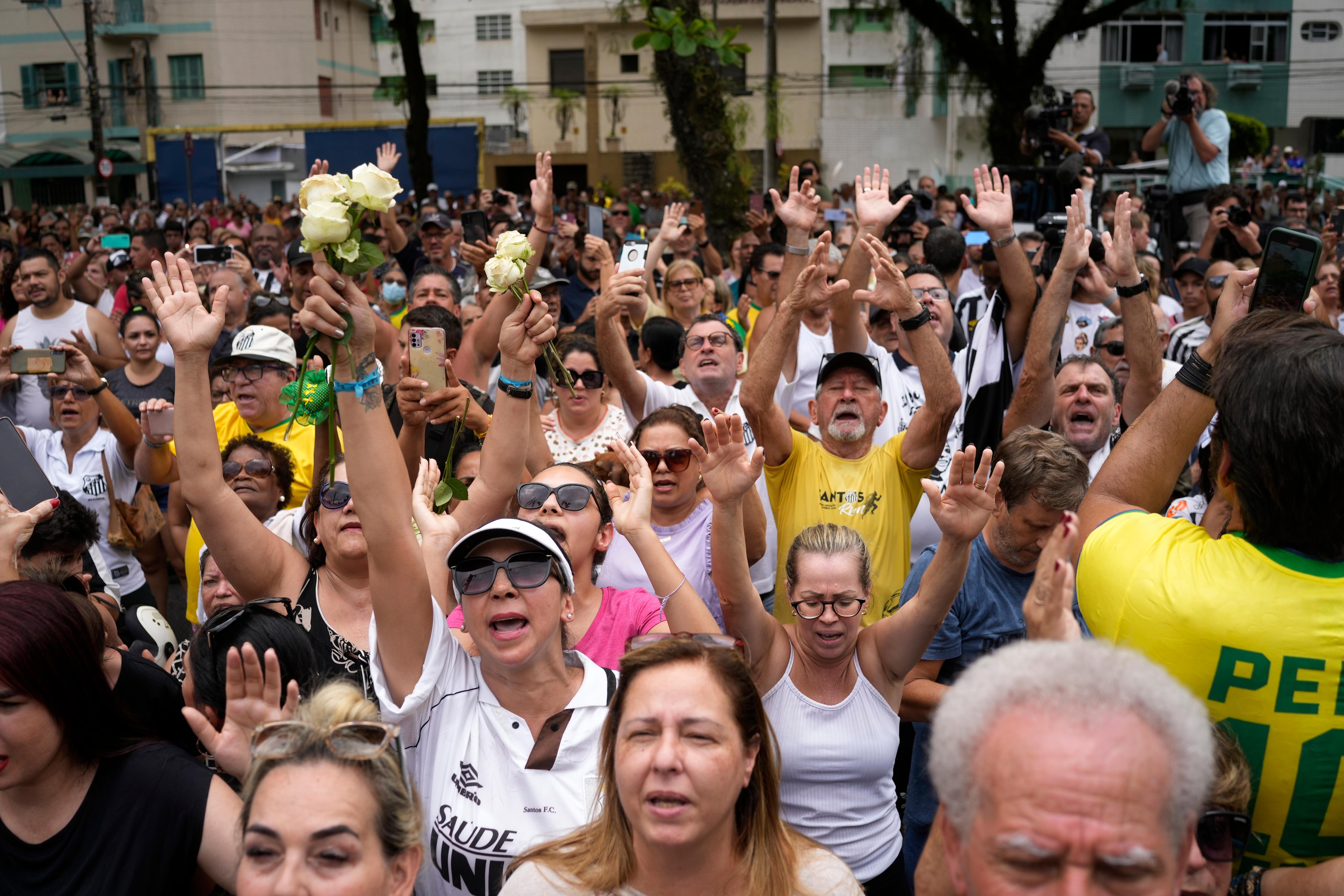 Brazillian soccer fans line the streets of Santos as Pelé's body is ...