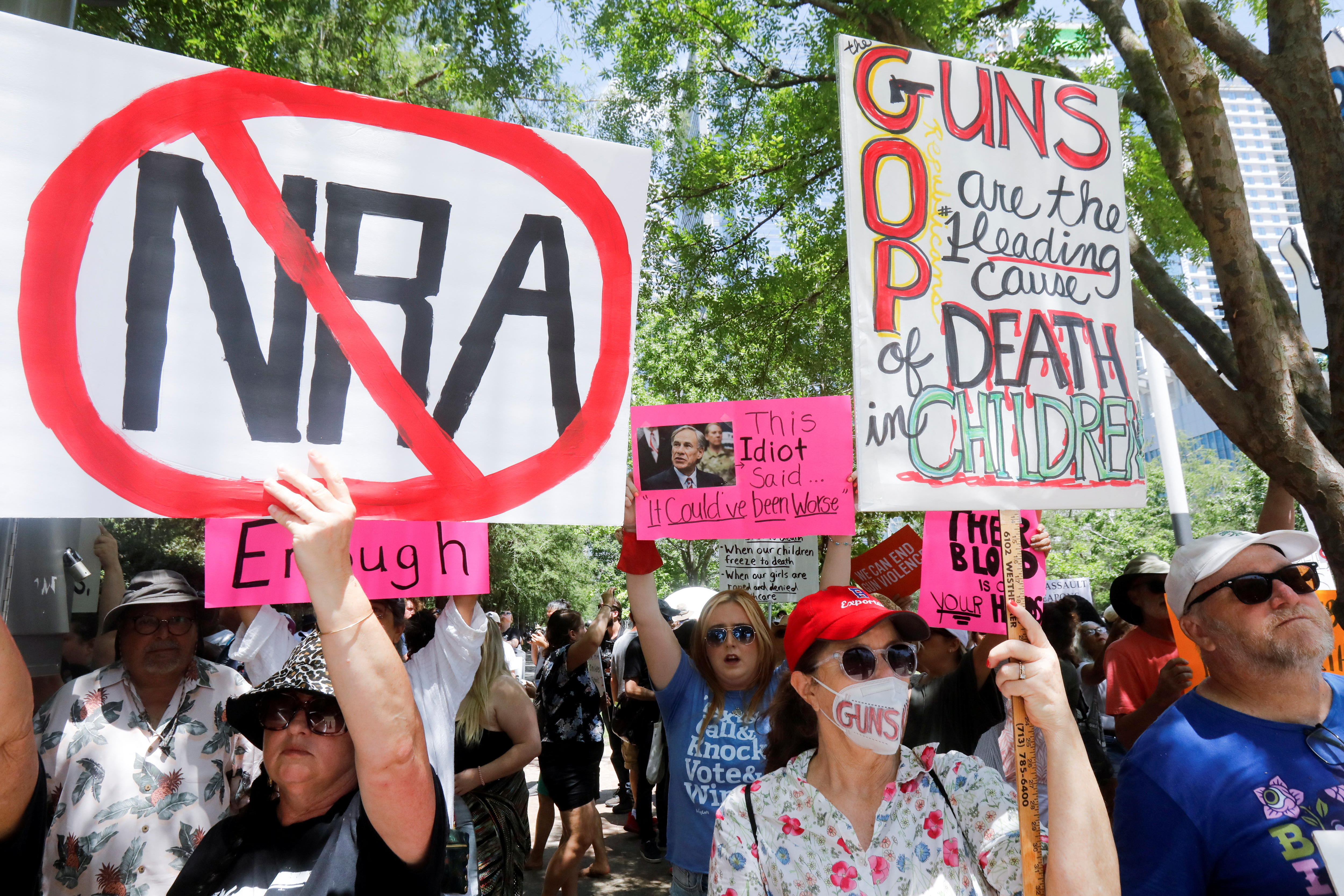 Protesters holding photos of shooting victims gather outside NRA ...