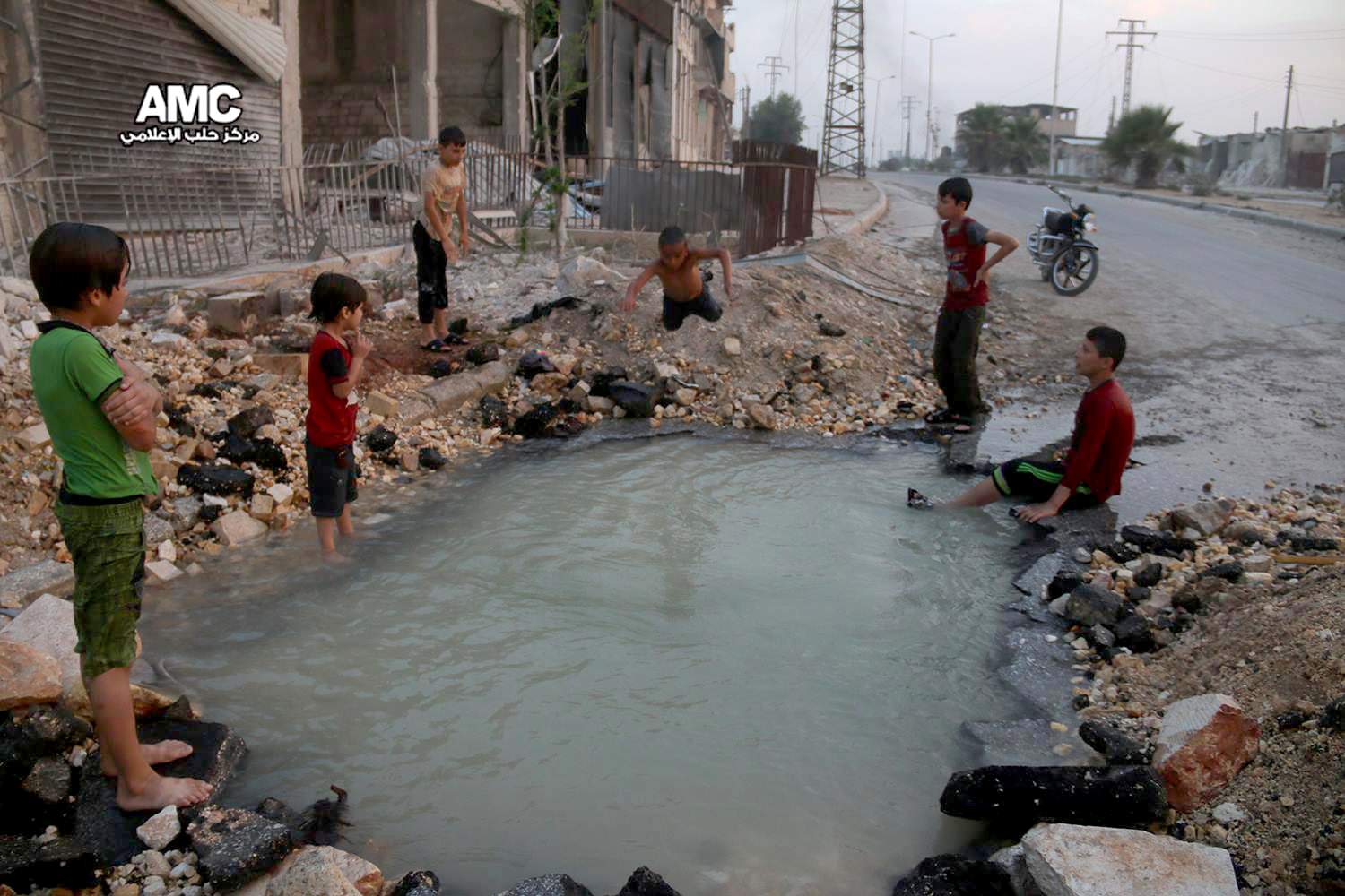 Syrian boys swim in water-filled crater in battleground of Aleppo - ABC ...