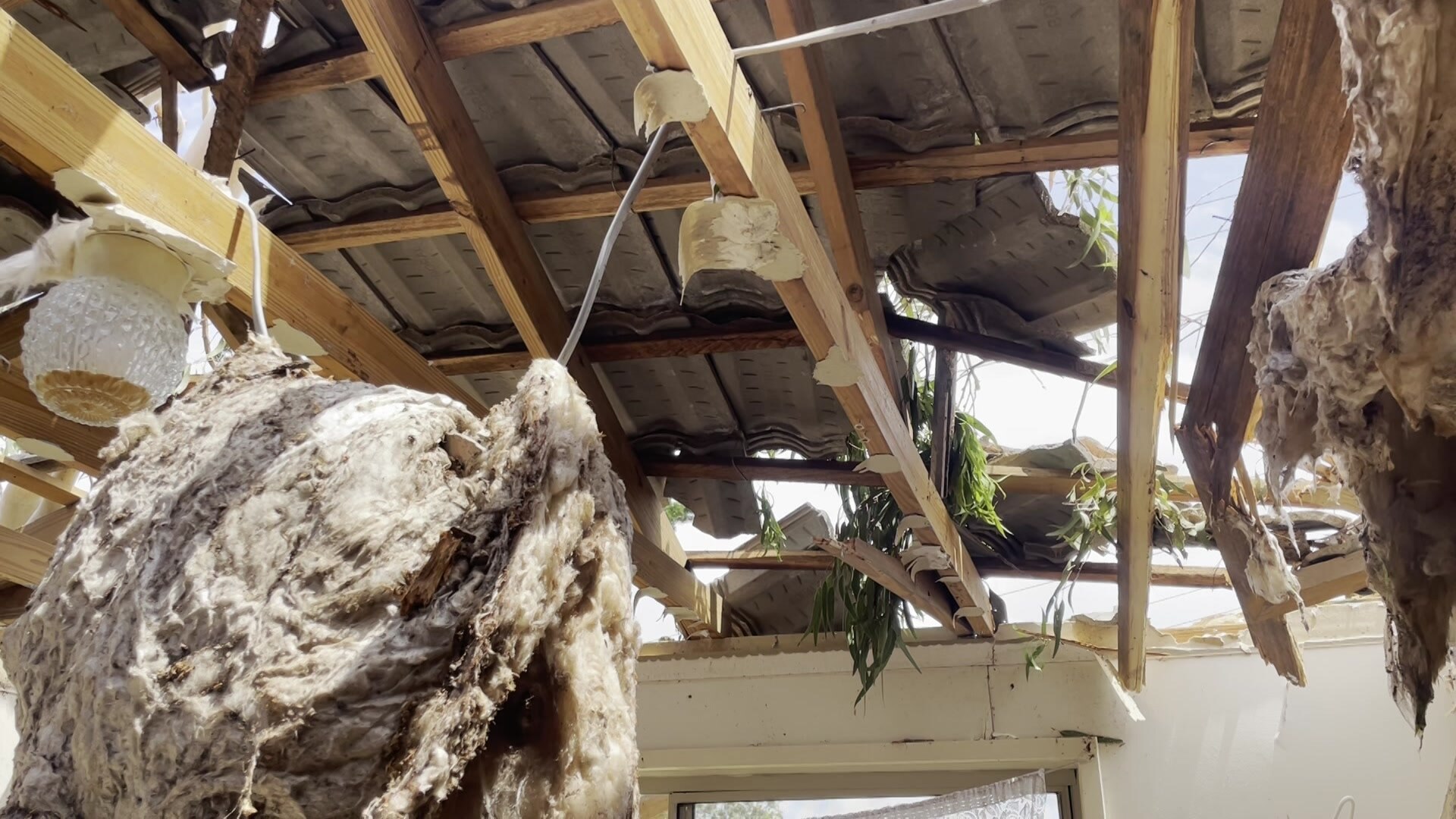 The storm brought down a tree branch onto a roof, smashing it to pieces ...