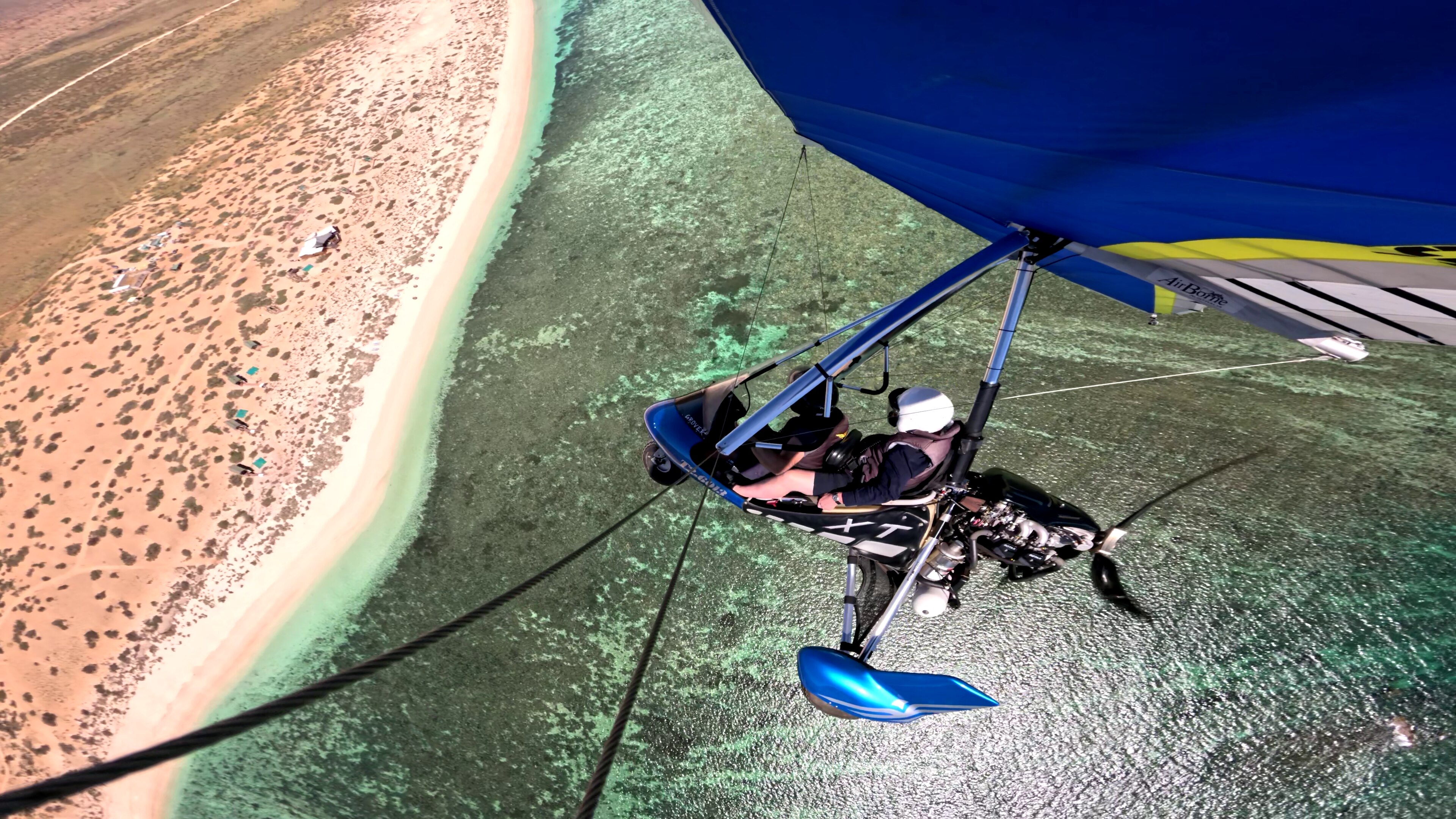 Two people on a hang glider assess the damage to the Ningaloo Reef near ...