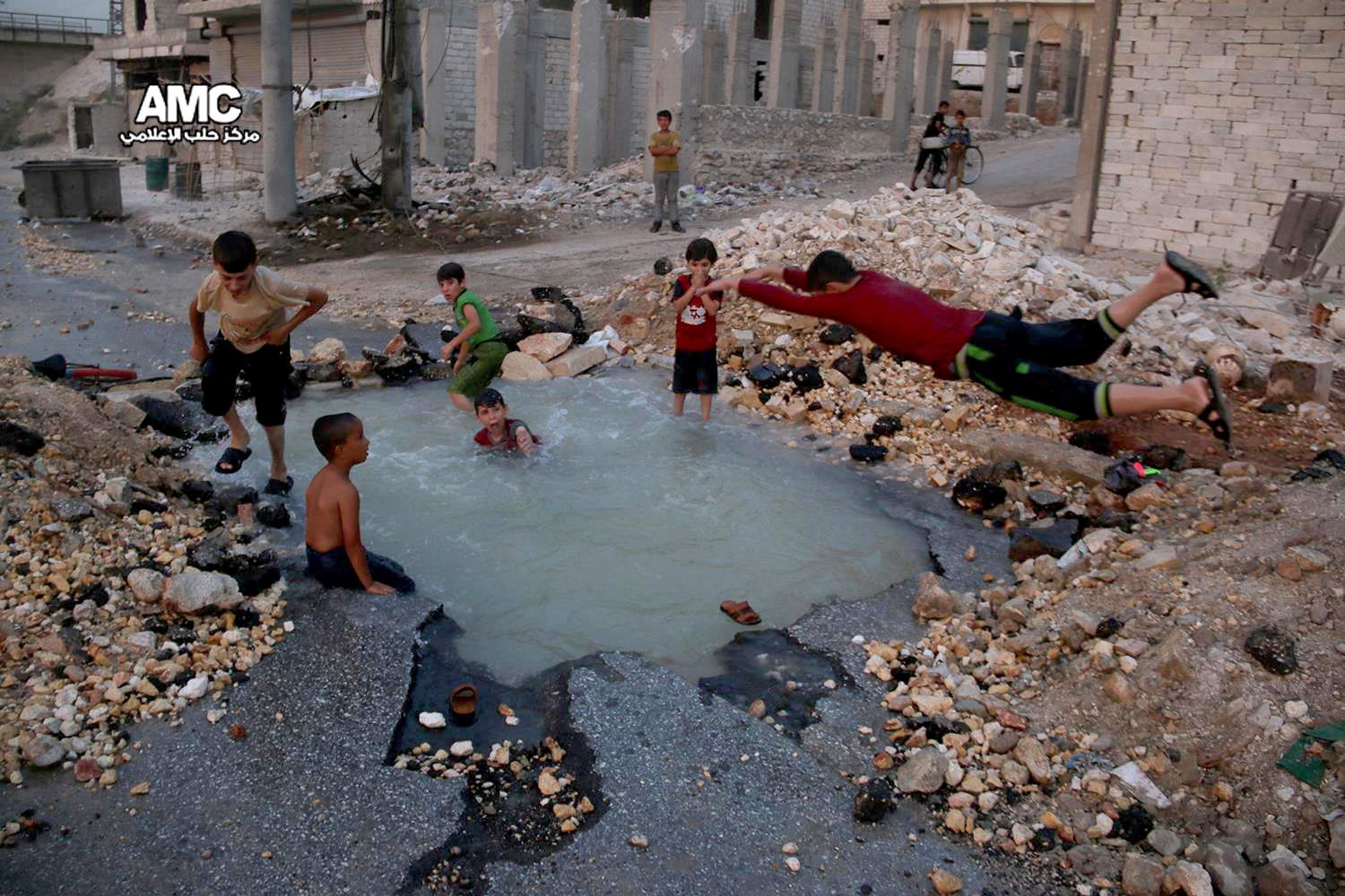 Syrian boys swim in water-filled crater in battleground of Aleppo - ABC ...