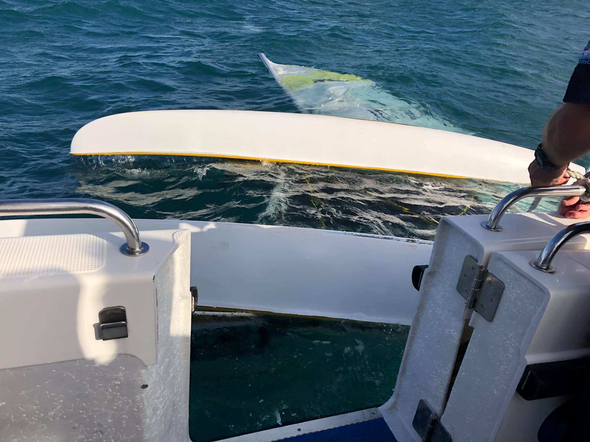 Man swims through rough seas to get help as woman clings to capsized ...