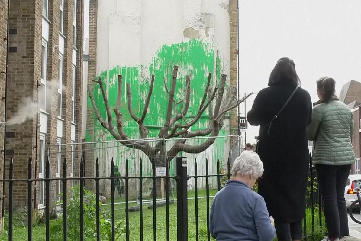 Banksy tree artwork defaced days after appearing, prompting temporary ...