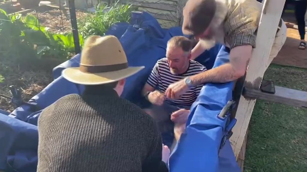 Elizabeth Struhs's father Jason being baptised in a backyard tub - ABC News
