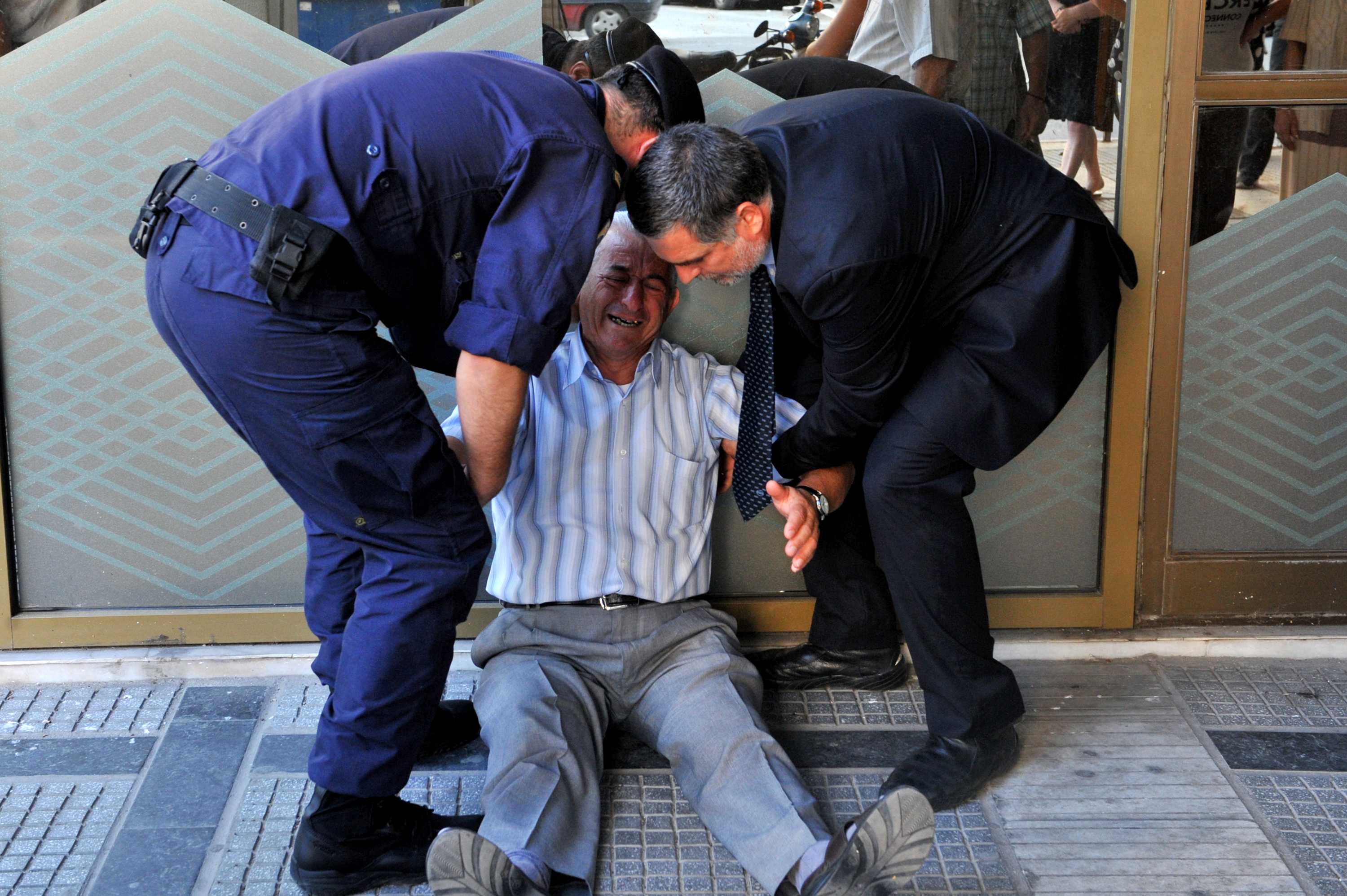 Greek debt crisis: Photograph of elderly man collapsed outside bank ...