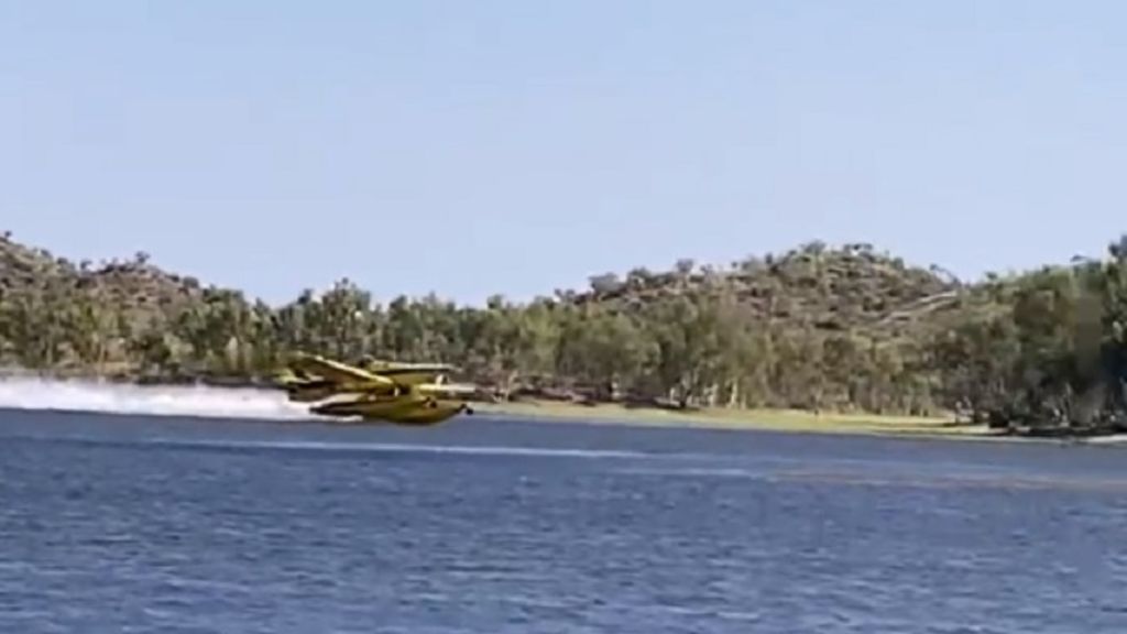 A fire waterbomber fills its tank near Mt Isa (Supplied) - ABC News