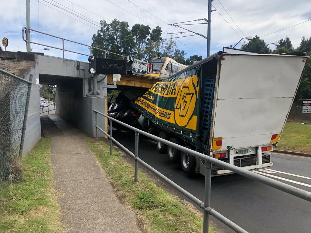 Truck jams under low rail bridge on Oxley Road at Corinda for second ...