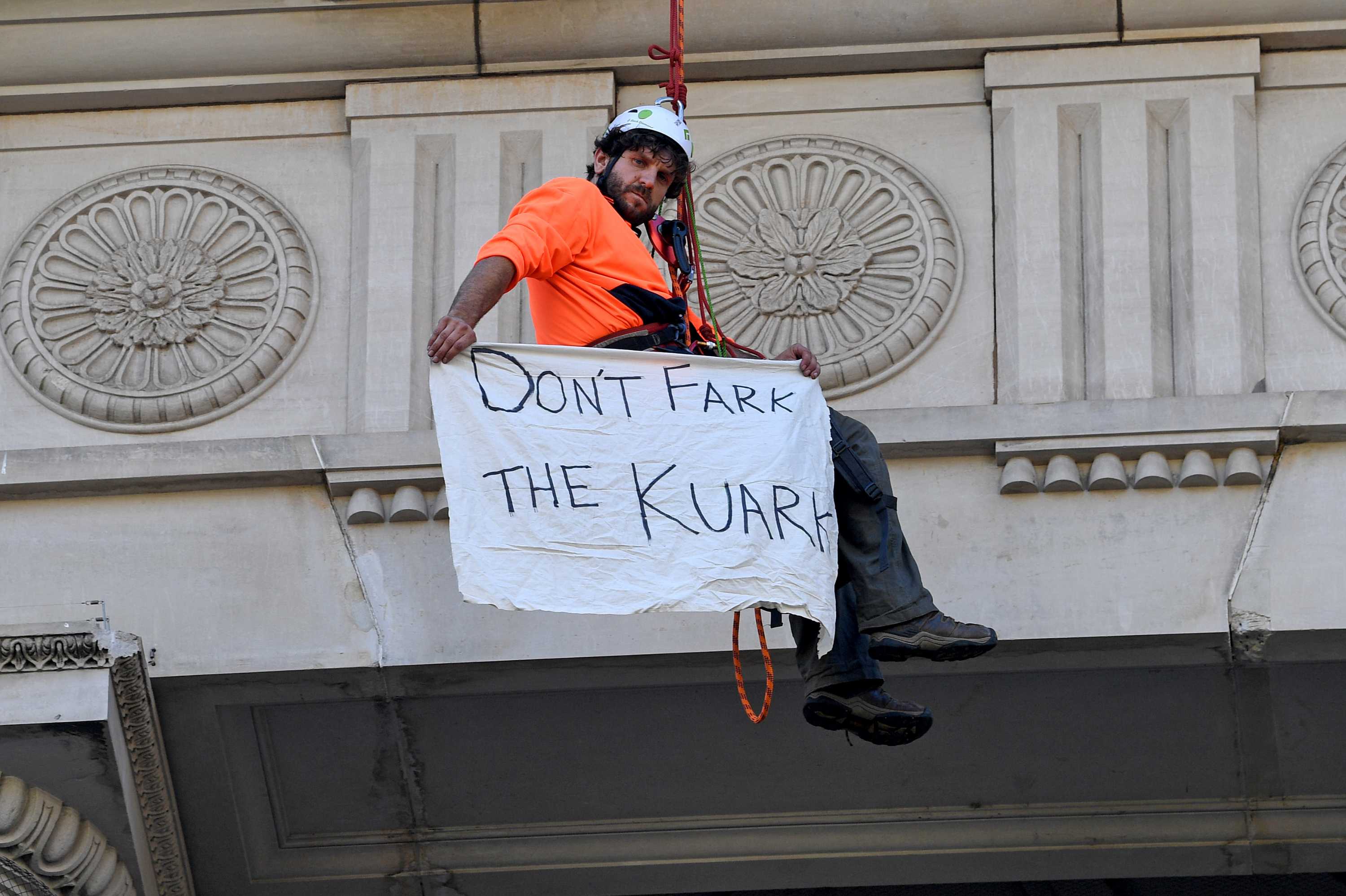 Protester abseils down Victorian Parliament a day after man charged ...