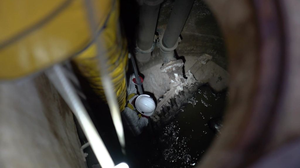 Crews winched down a manhole to remove a blockage - ABC News